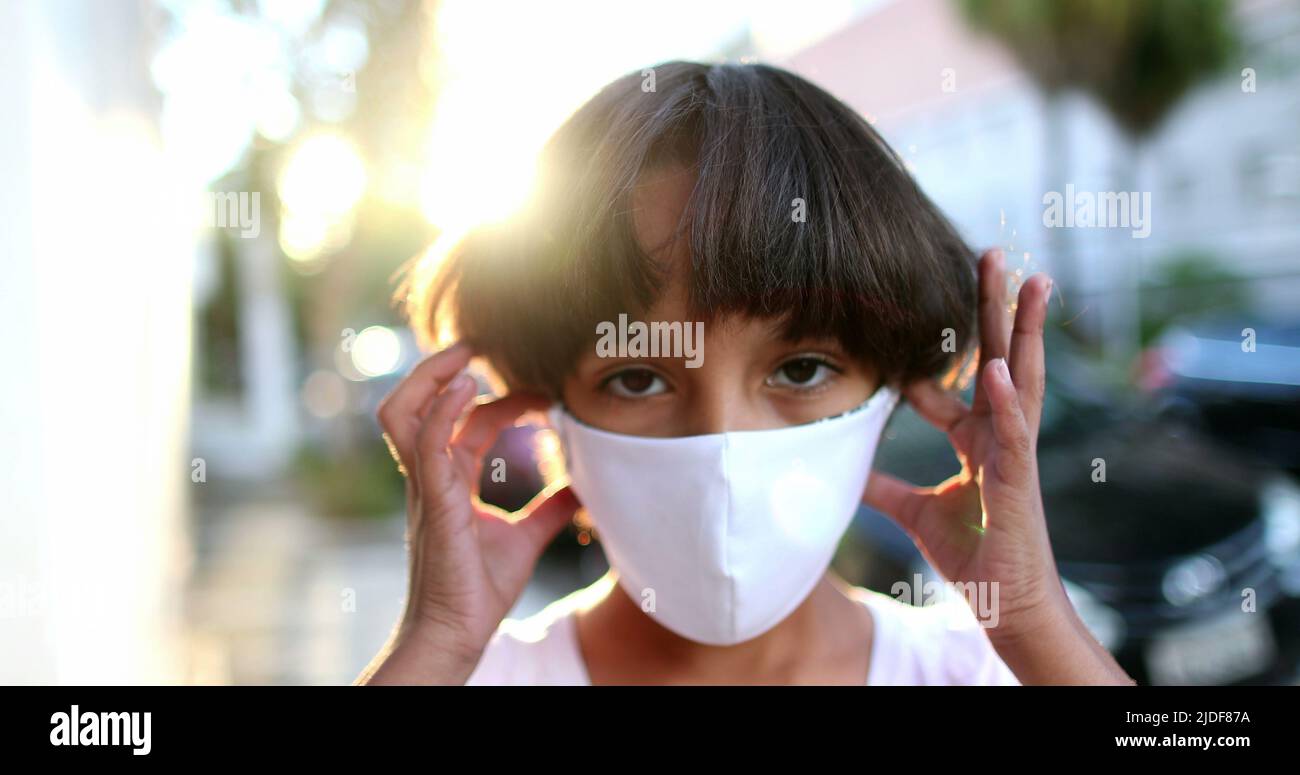 Happy boy removing covid-19 coronavirus face mask outside in sunlight ...