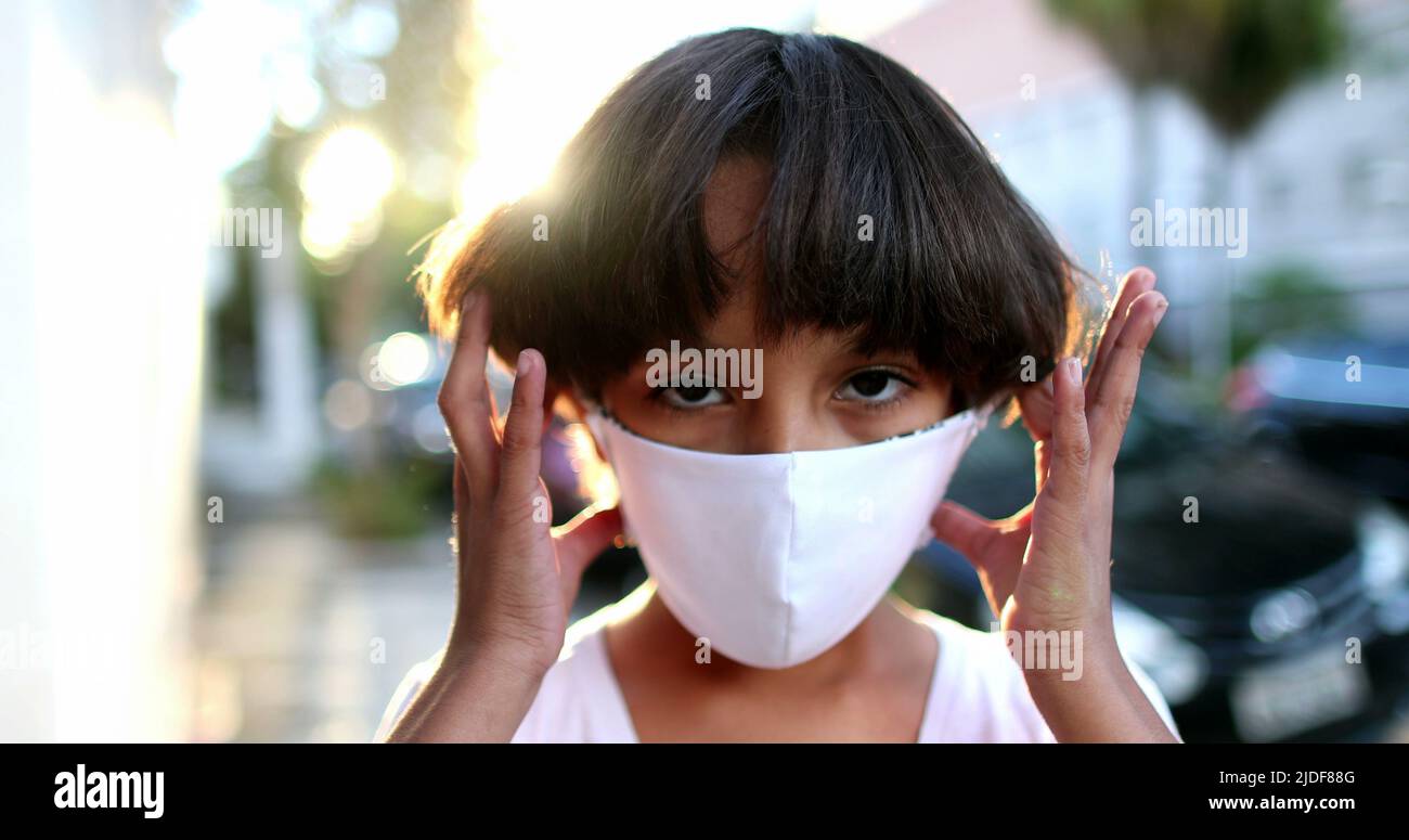 Happy boy removing covid-19 coronavirus face mask outside in sunlight ...