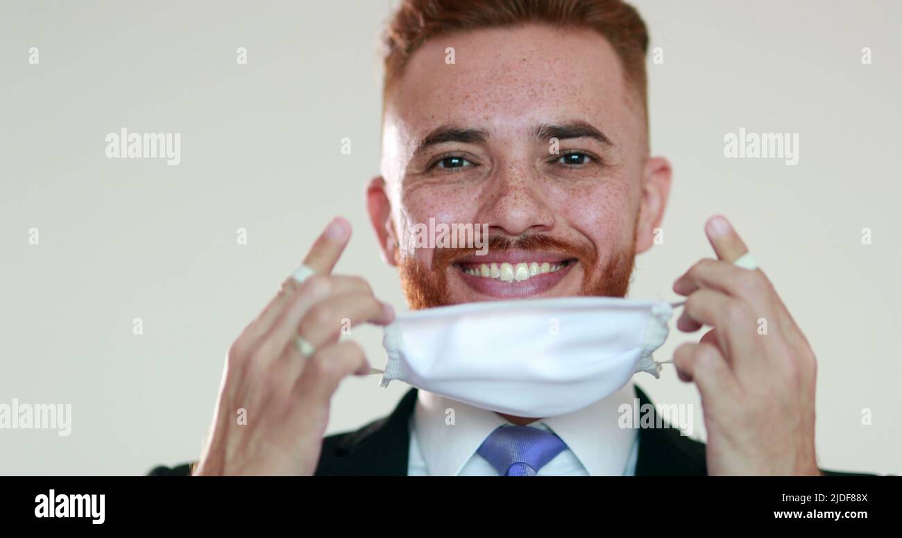 Handsome redhair businessman removing surgical mask after pandemic ...
