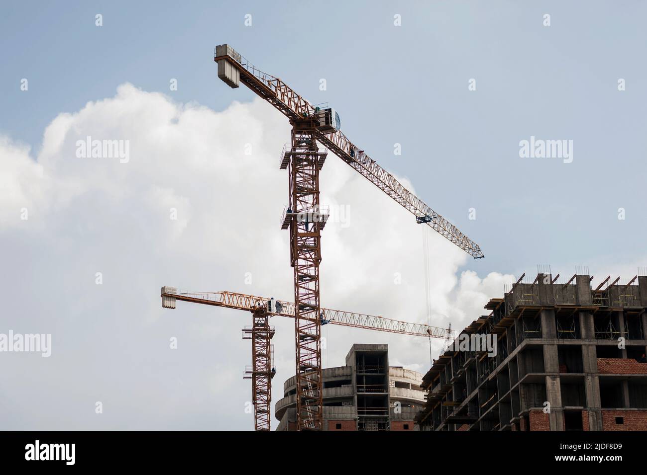 two tower cranes on the construction of the building. industrial ...