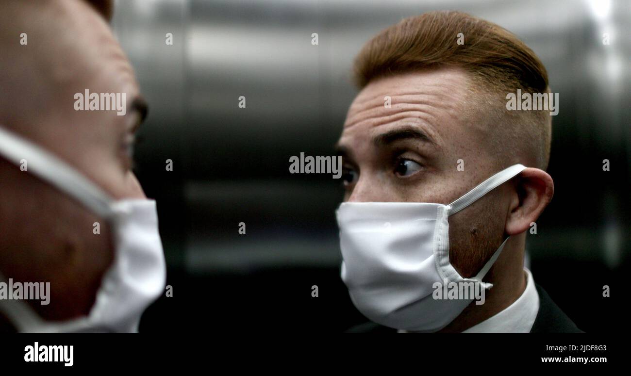 Man touching face with hand wearing surgical mask, person rubbing face ...