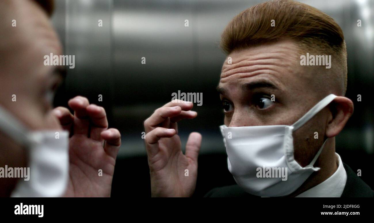 Man touching face with hand wearing surgical mask, person rubbing face ...