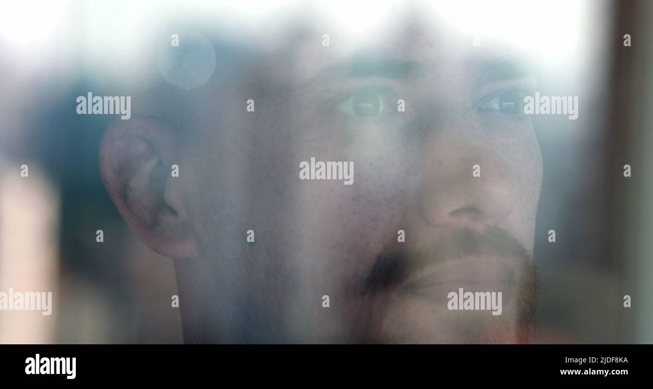 Pensive man looking outside through window. Thoughtful person thinking ...