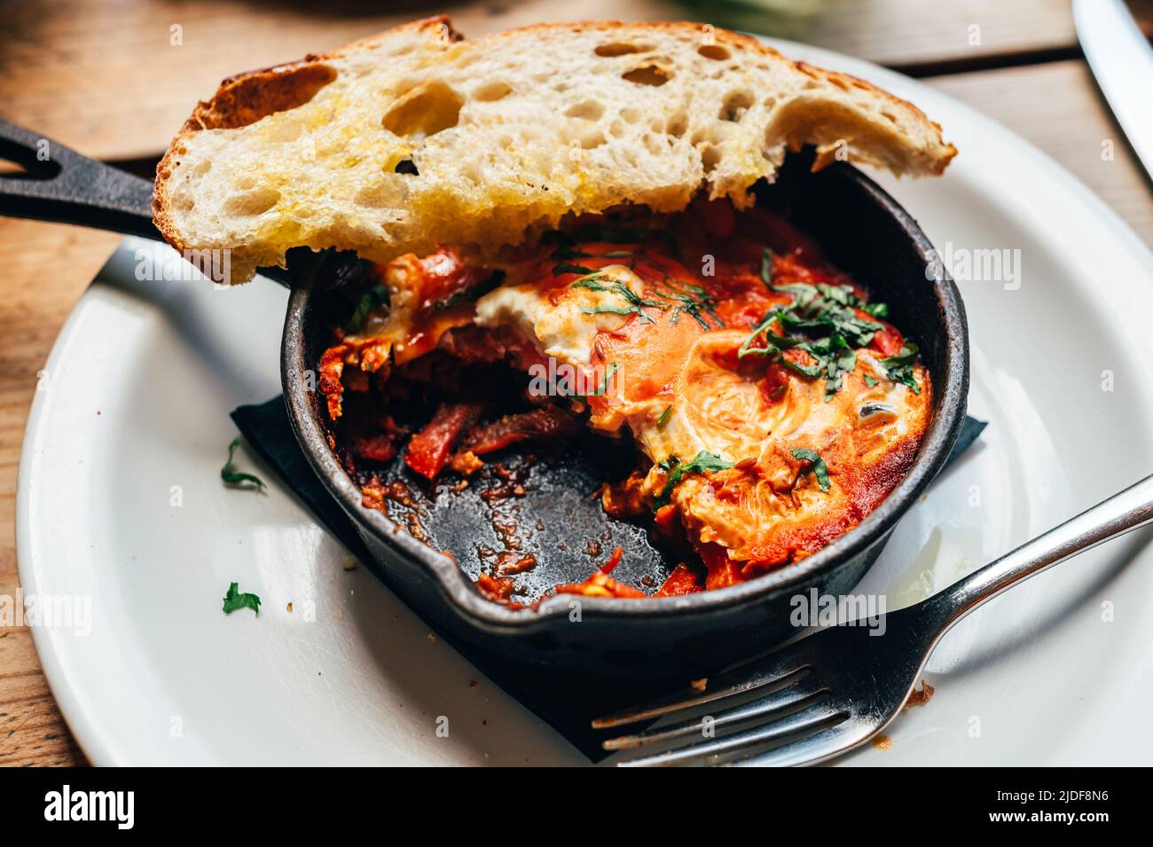 Shakshuka in iron pan served with bread Stock Photo - Alamy