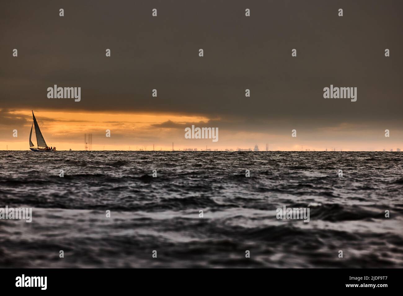 Sailboat in sea at stormy weather, stormy clouds sky orange sky, sail ...