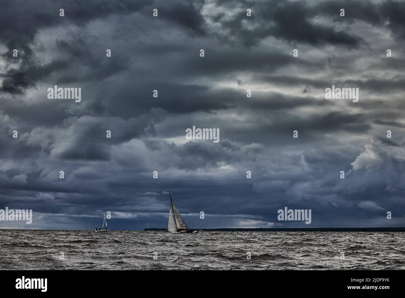 Sailboat in sea at stormy weather, stormy clouds sky orange sky, sail ...