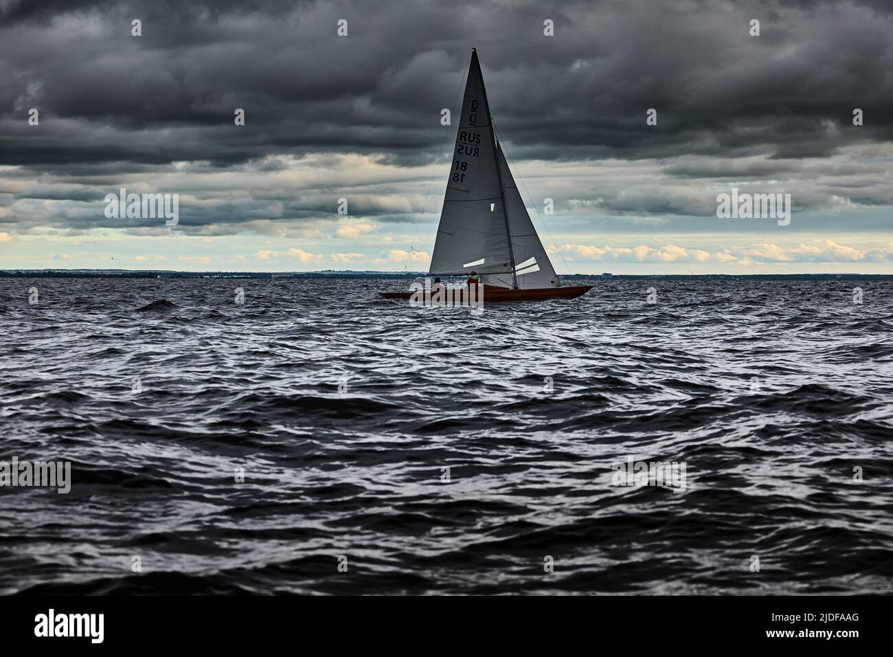 Sailboat in sea at stormy weather, stormy clouds sky orange sky, sail ...