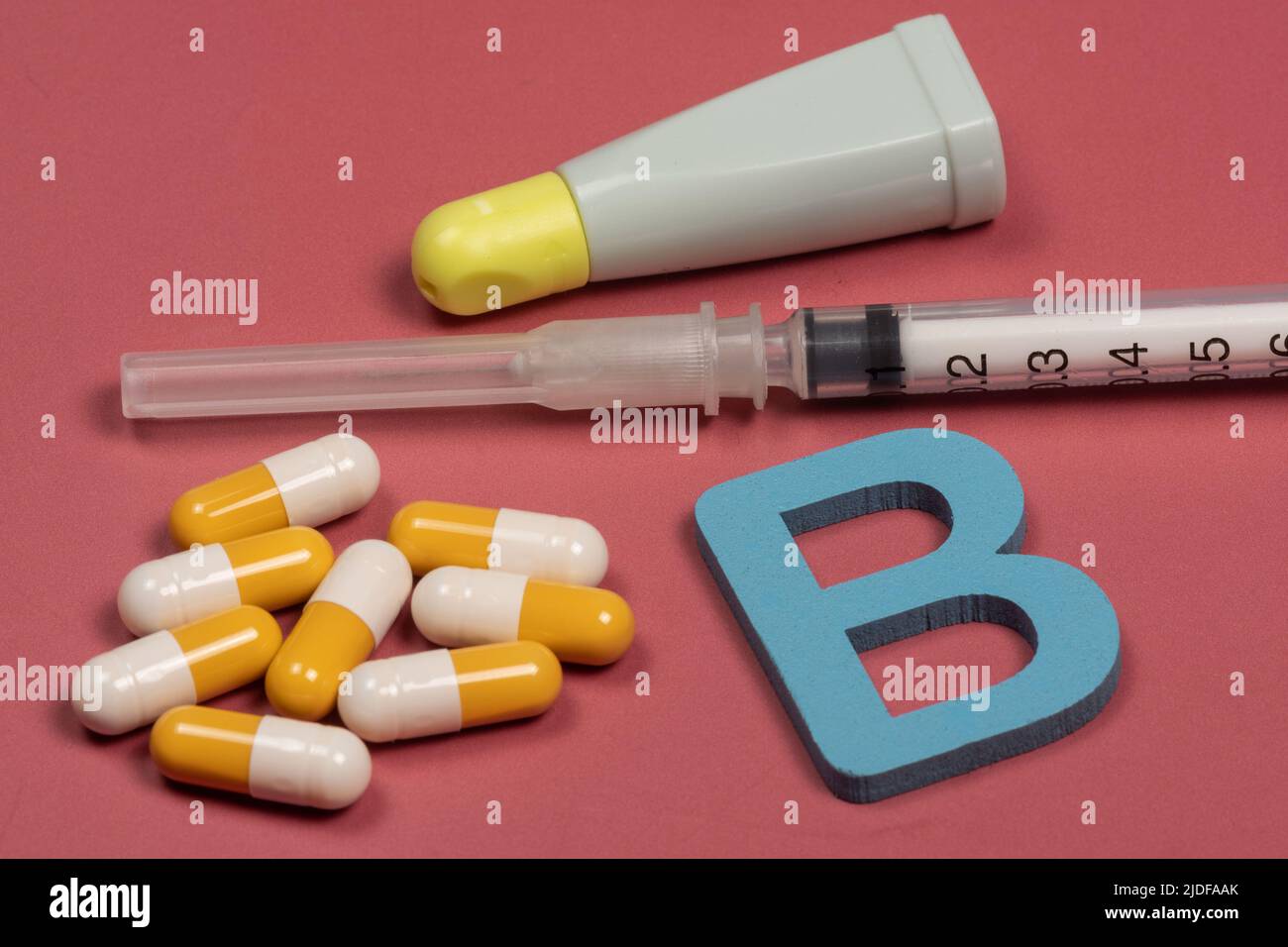 yellow and white medicine capsules on red background and insulin ...