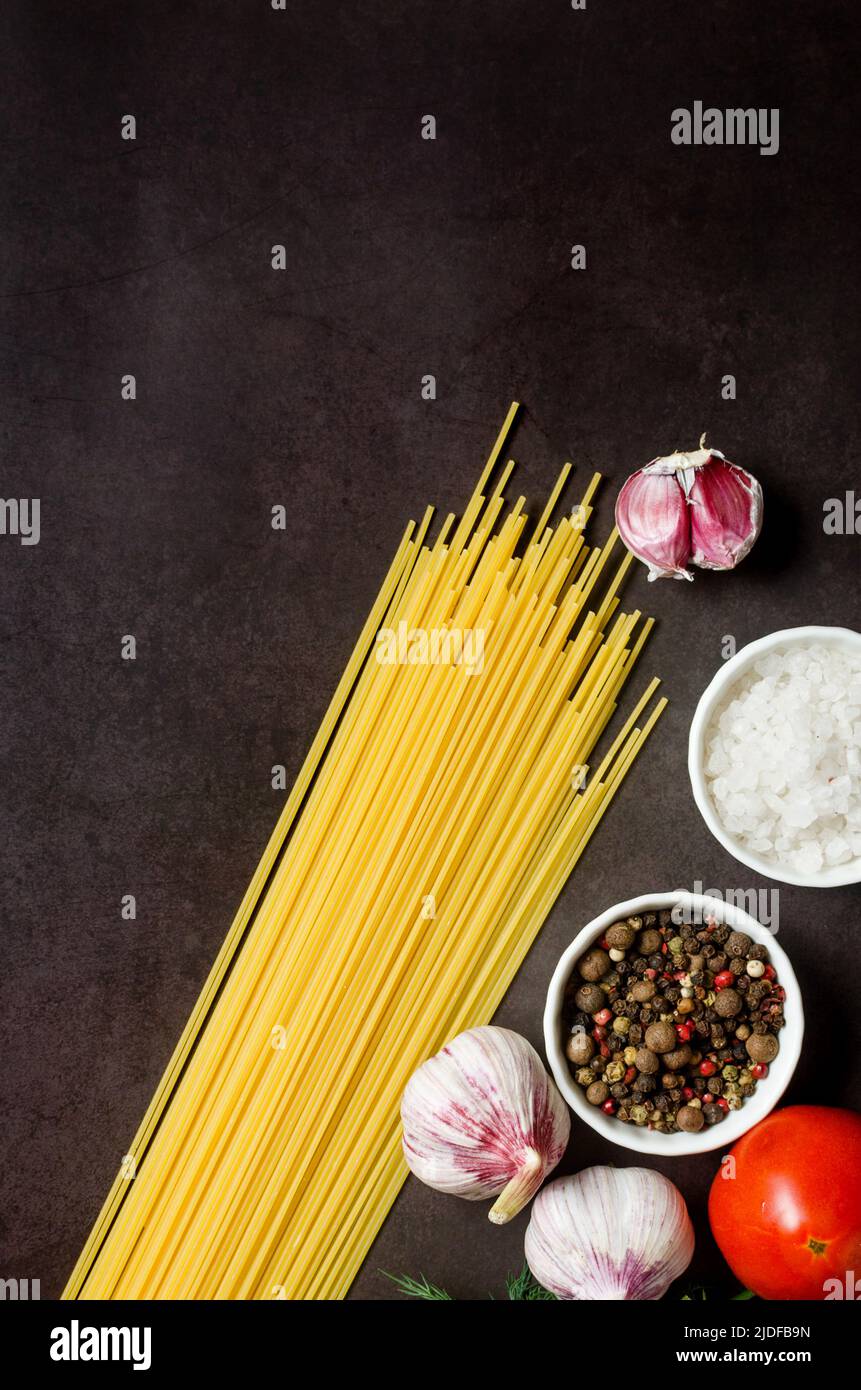 Raw long spaghetti with ingredients for cooking, marrow, tomatoes ...
