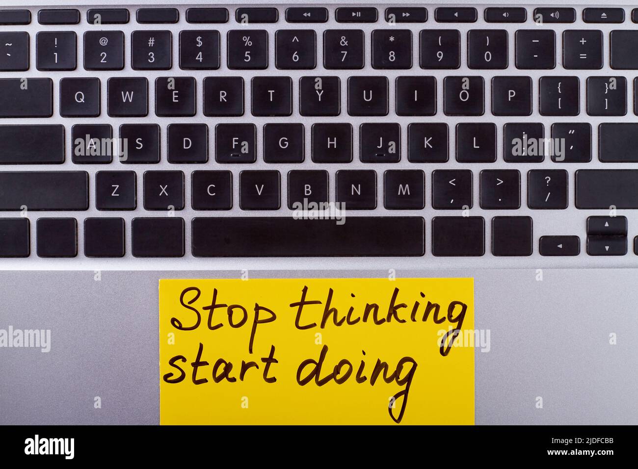 Laptop keyboard with stop thinking start doing slogan. Motivation motto ...