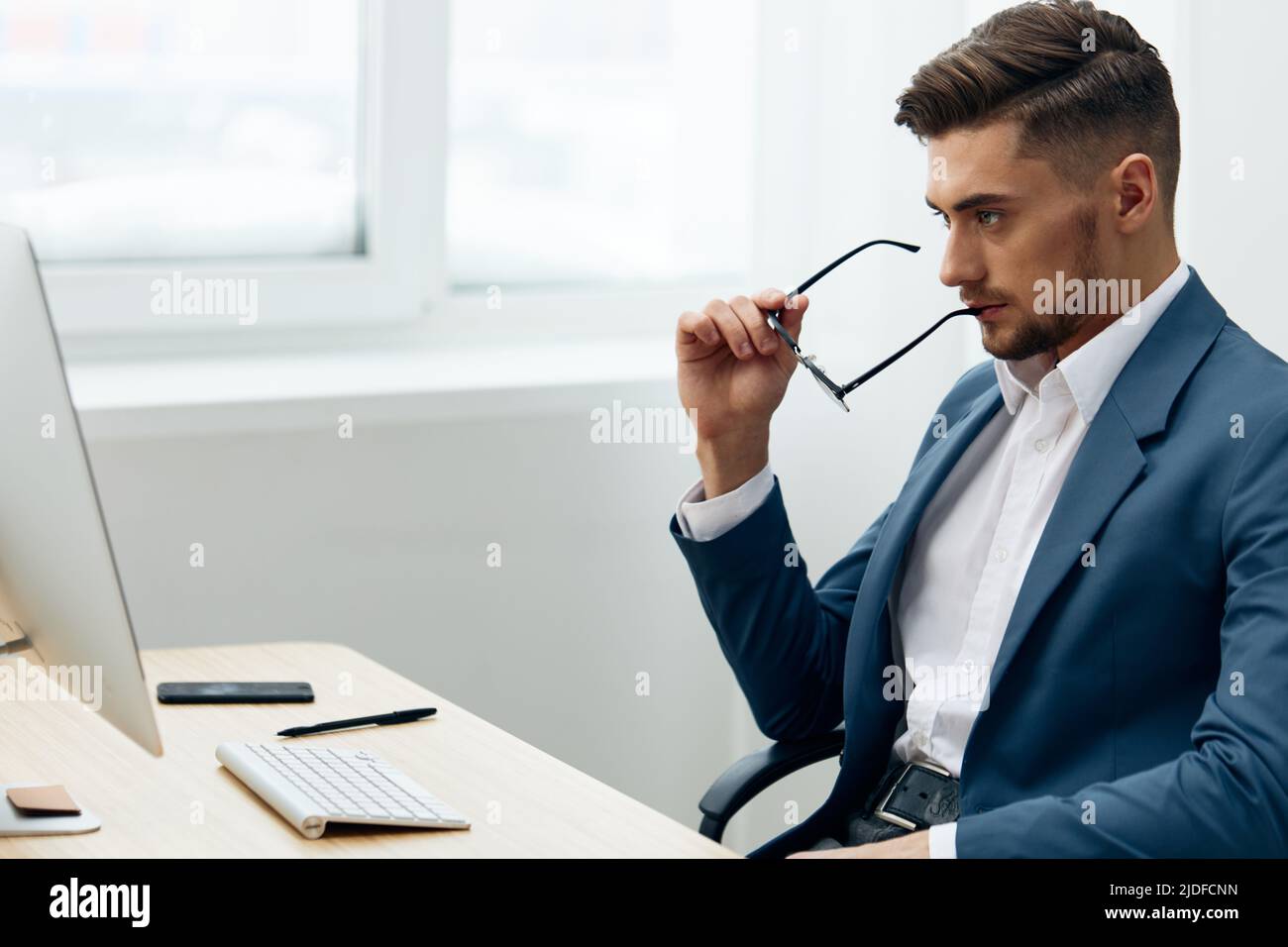 a man in a suit sitting at the computer work boss technologies Stock ...
