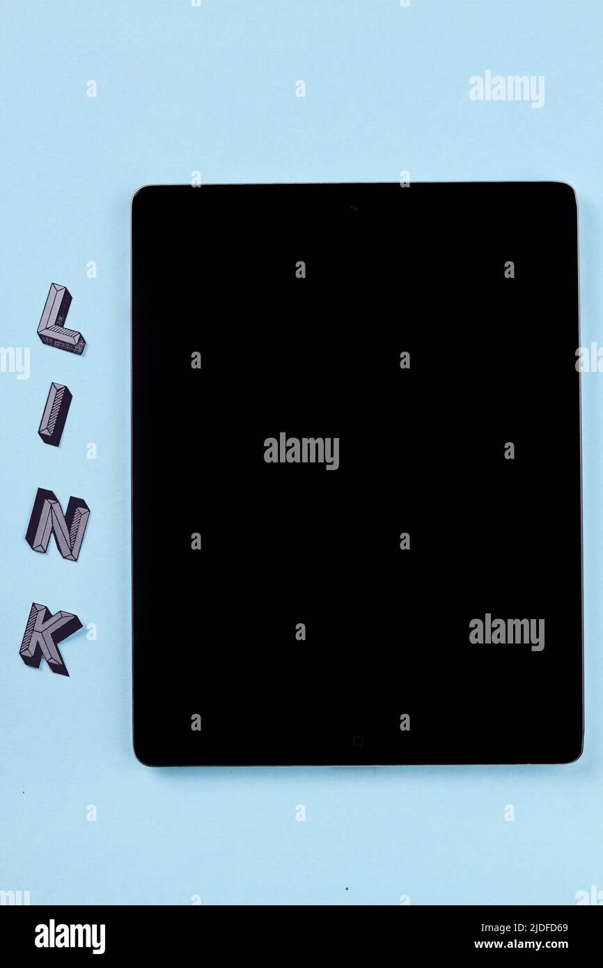 Tablet pc with black screen on blue background. Vertical shot link word ...