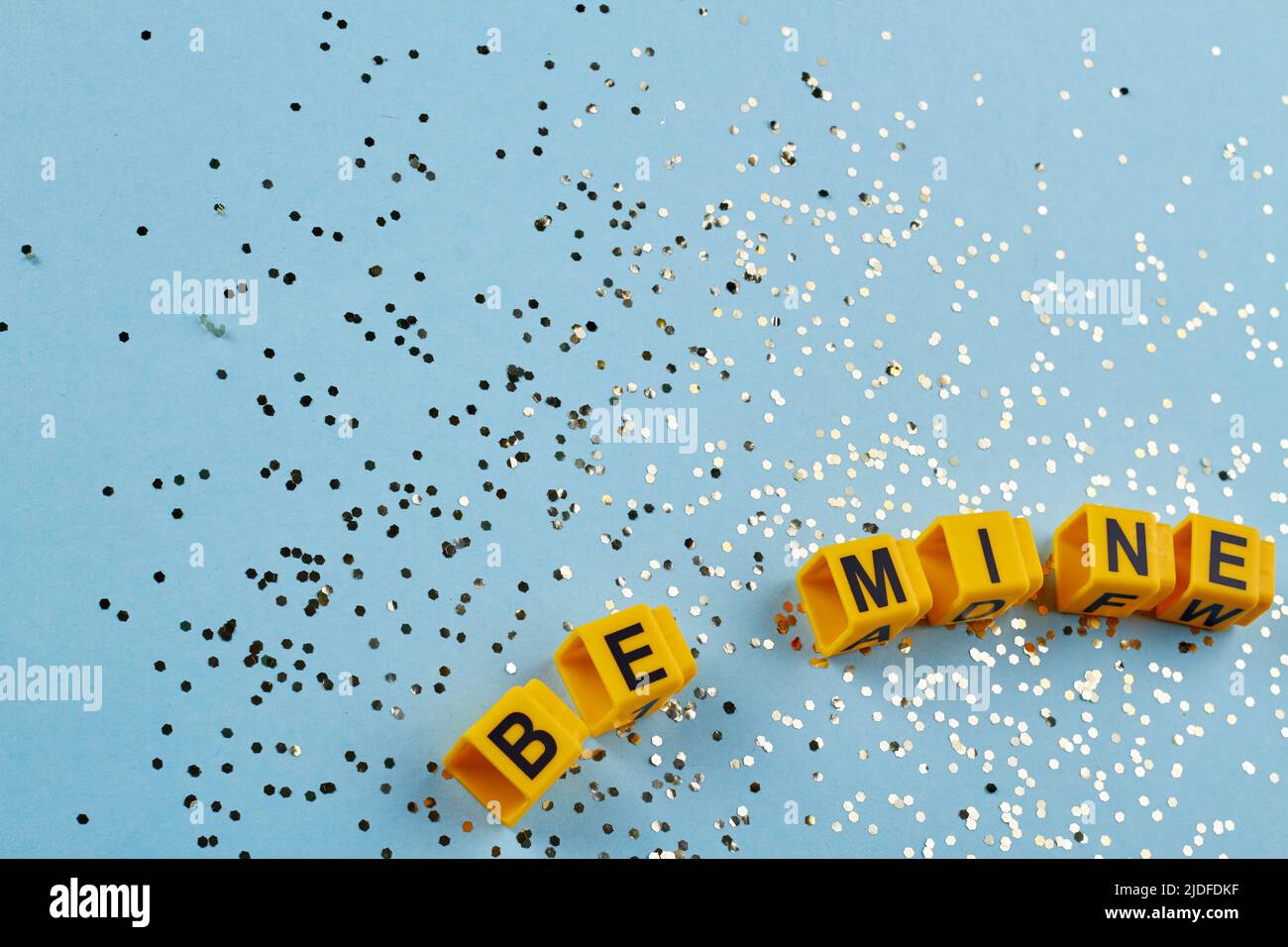 Yellow letter with be mine proposal and many sequins. Blue background ...