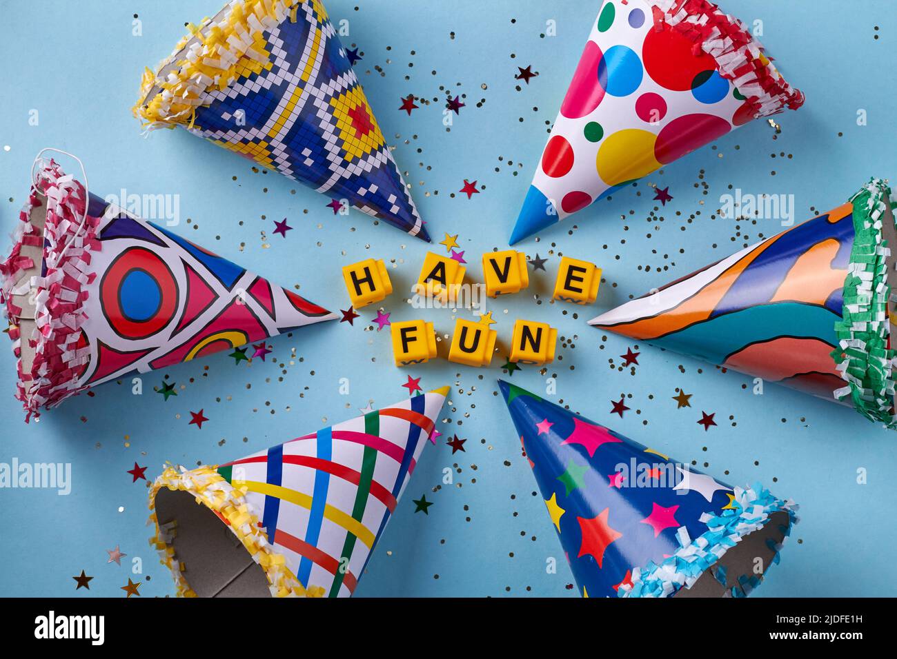 Various birthday cones with confetti on blue background. Yellow letter ...