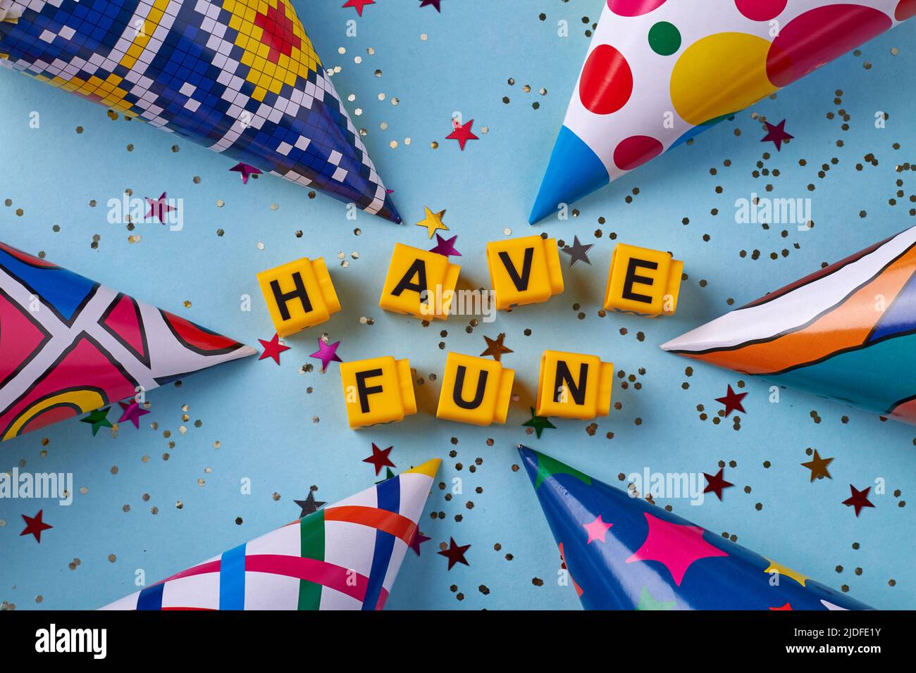 Have fun words with colorful birthday cones. Confetti on blue ...