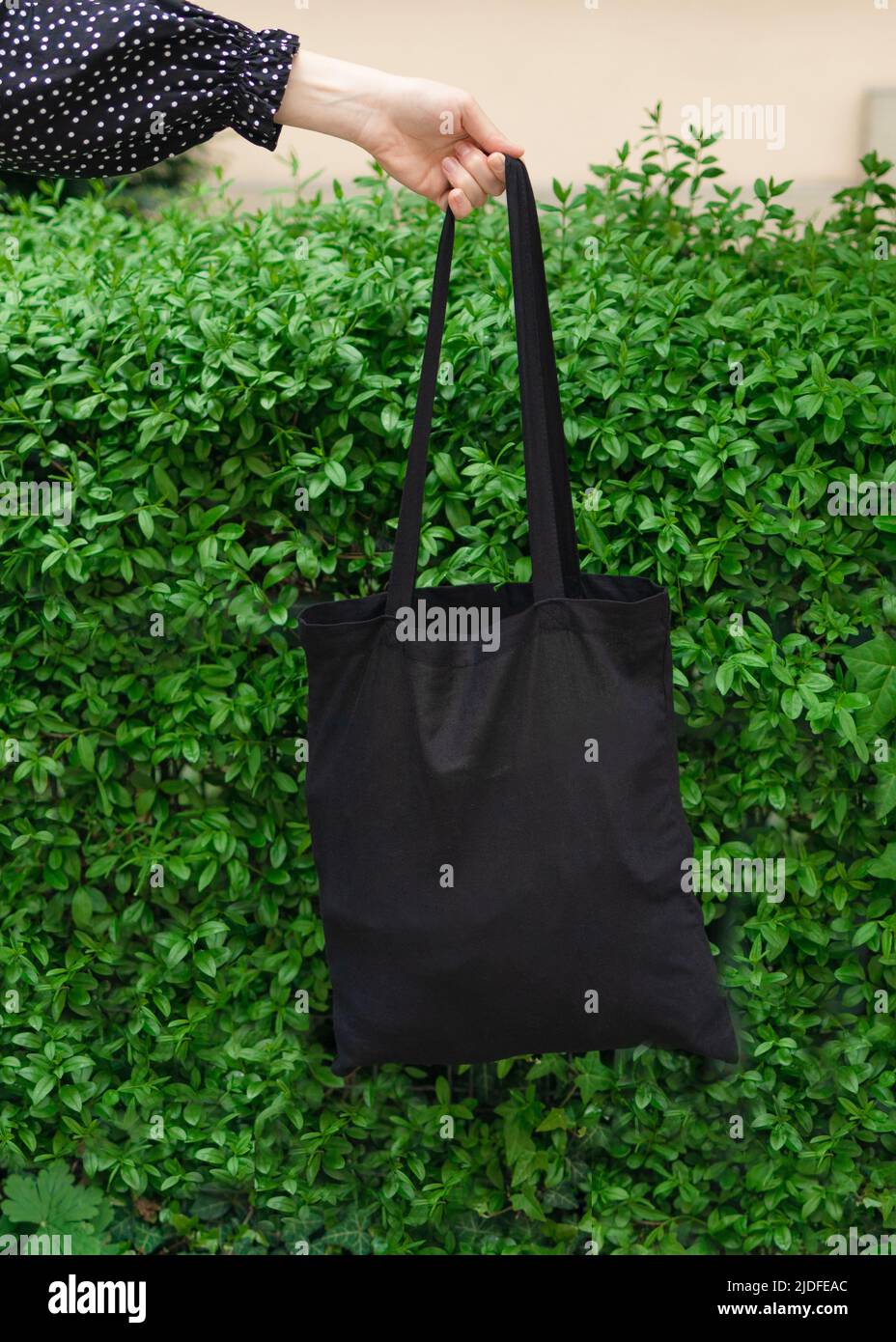 Woman hands holding black bag canvas fabric for mockup blank template ...