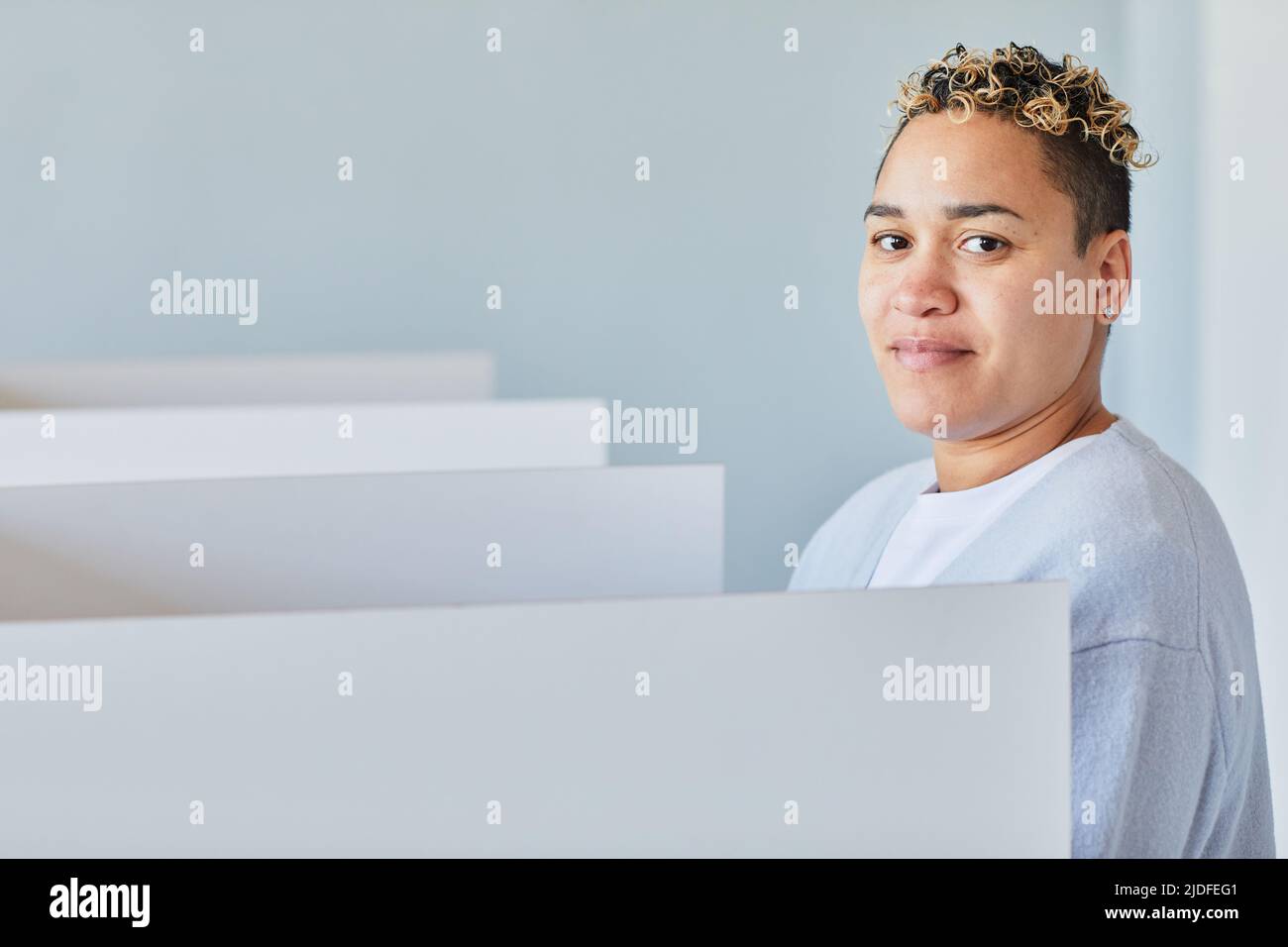 Minimal portrait of young black woman voting on election day and ...