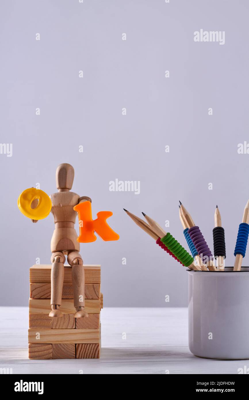 Vertical shot of wooden mannequin and cup of pencils. Dummy with or ...