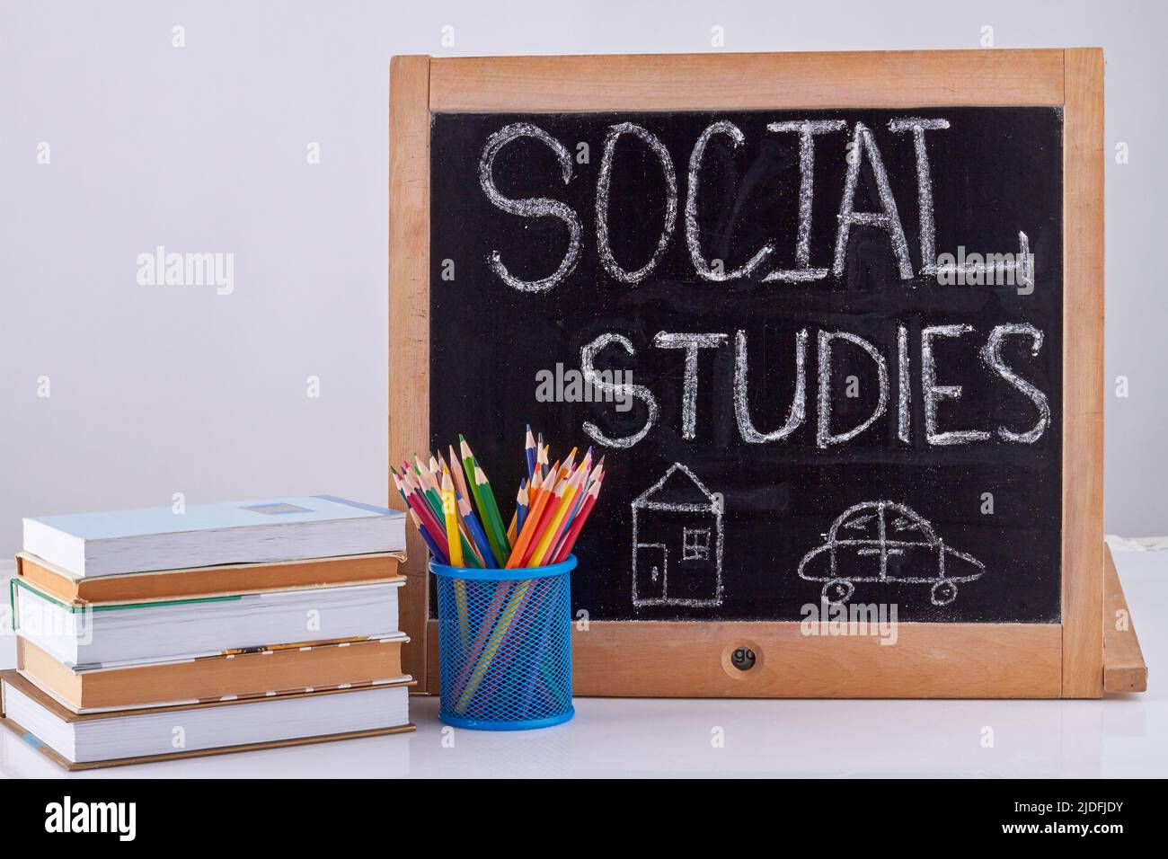 Blackboard with pencil cup and stack of books. Social studies concept ...