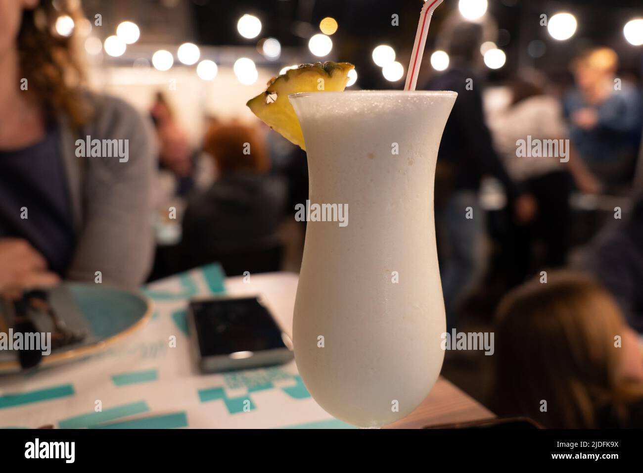 Pina Colada cocktail with slice of pineapple and straw. Blurry bokeh ...