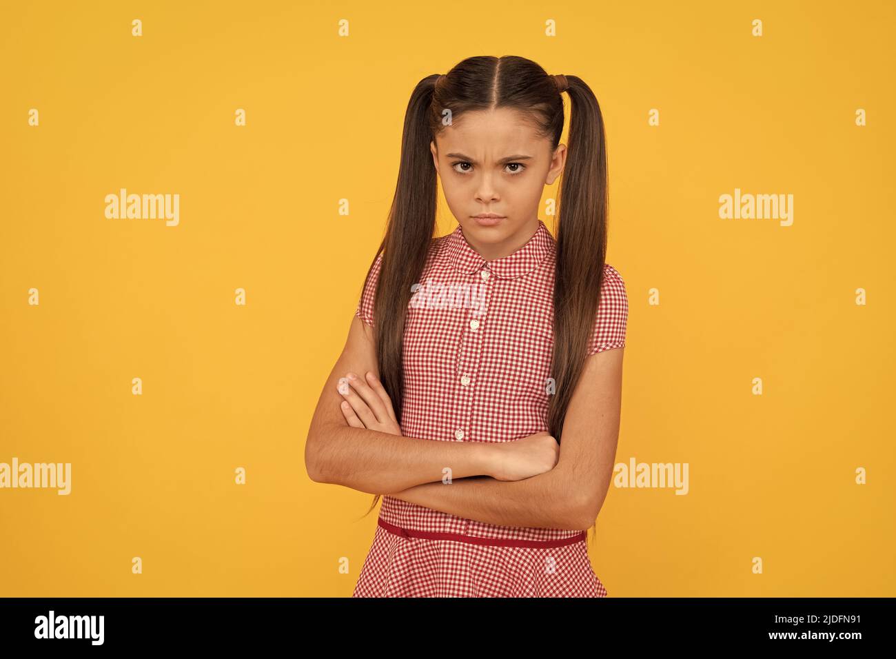 Too serious for her years. Serious school-aged child yellow background ...