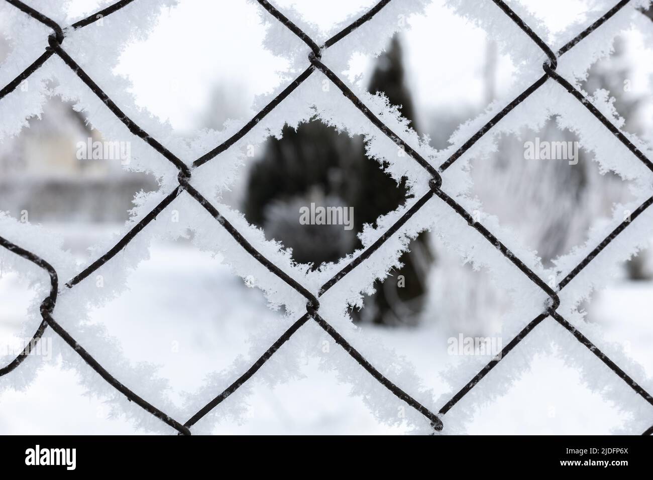 Close-up of iron thin insecure netting overlaid with snow with some ...