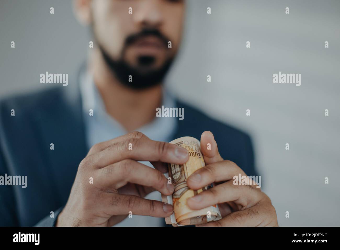 Depressed businessman man looking through a tube of money, inflation ...