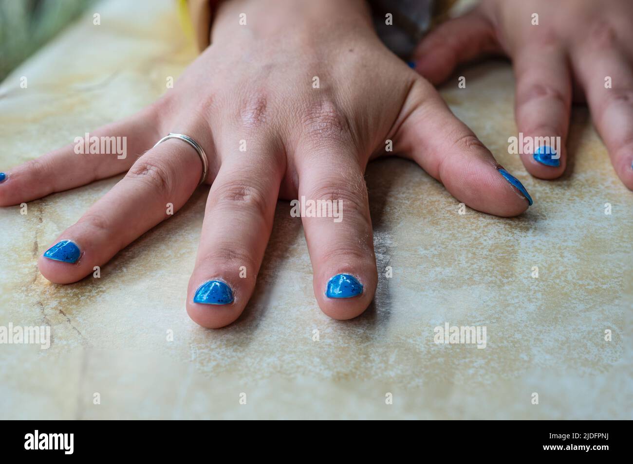 Hands with blue nail polish of a 35 year old white woman, Brussels ...