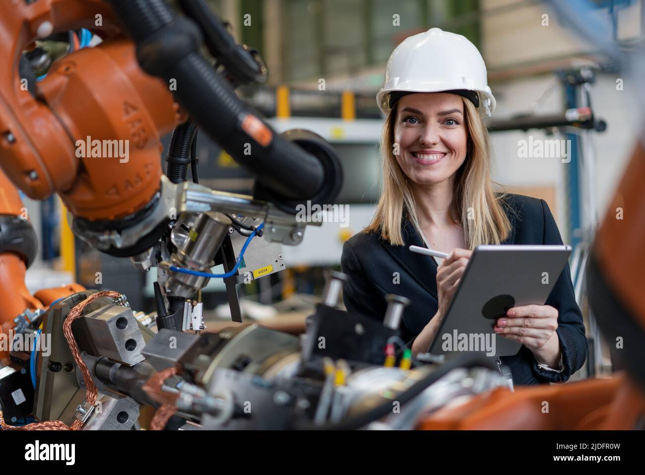 Female chief engineer in modern industrial factory using tablet and ...