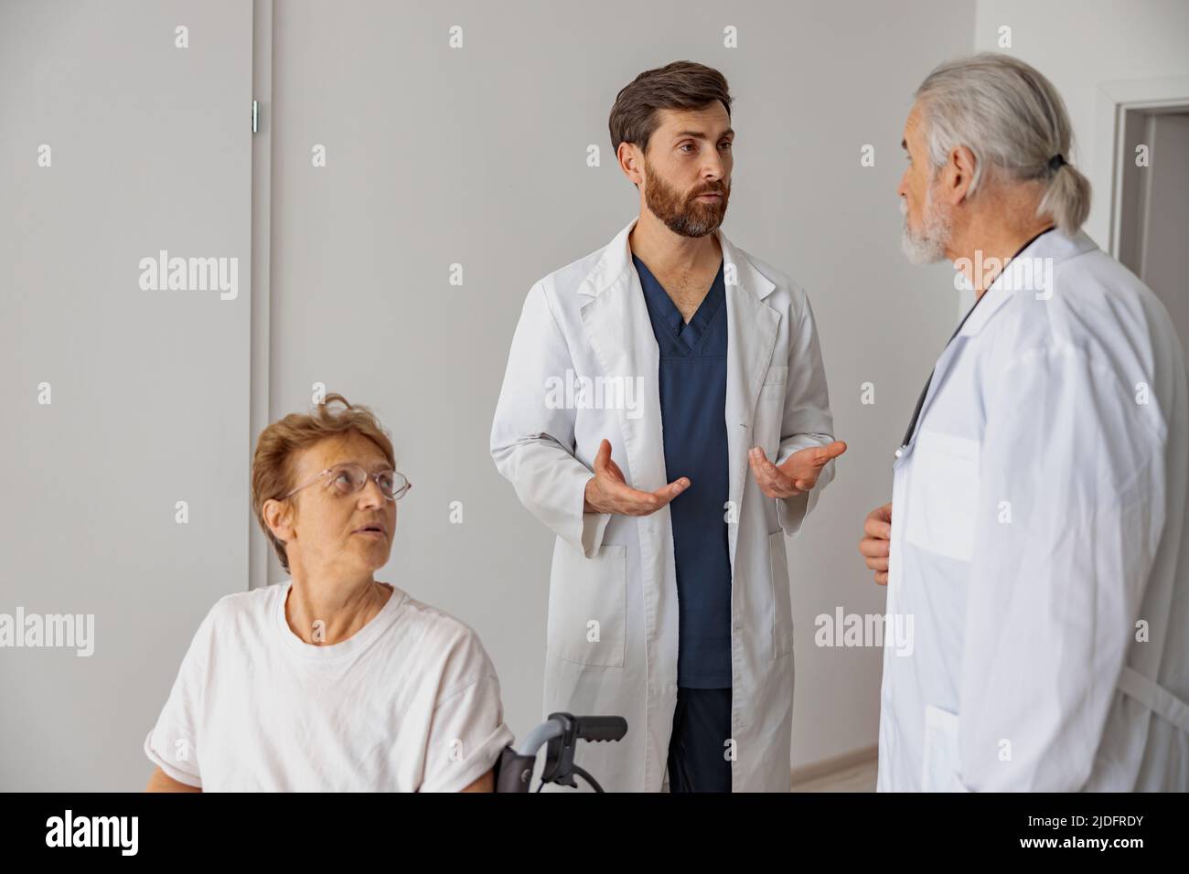 Professional doctors discuss over patient's diagnosis standing in ...