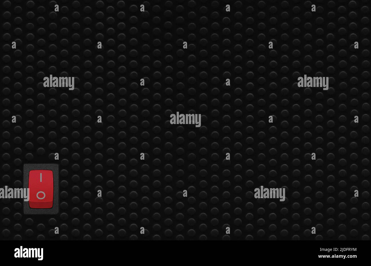 Red rectangle rocker power switch in on position, black abstract dot ...