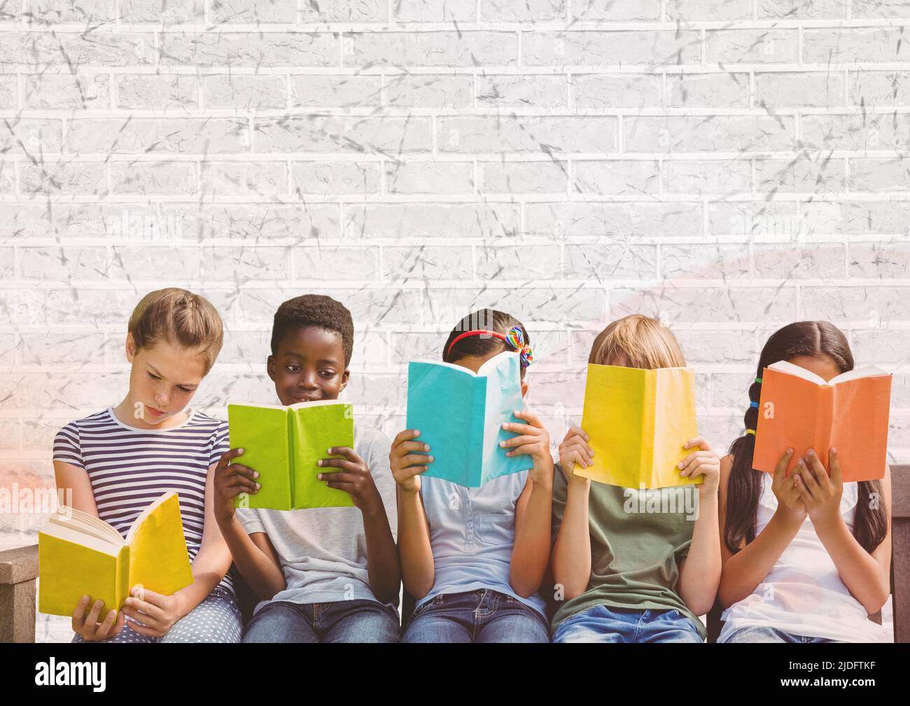 Group of diverse students reading books against grey brick wall ...