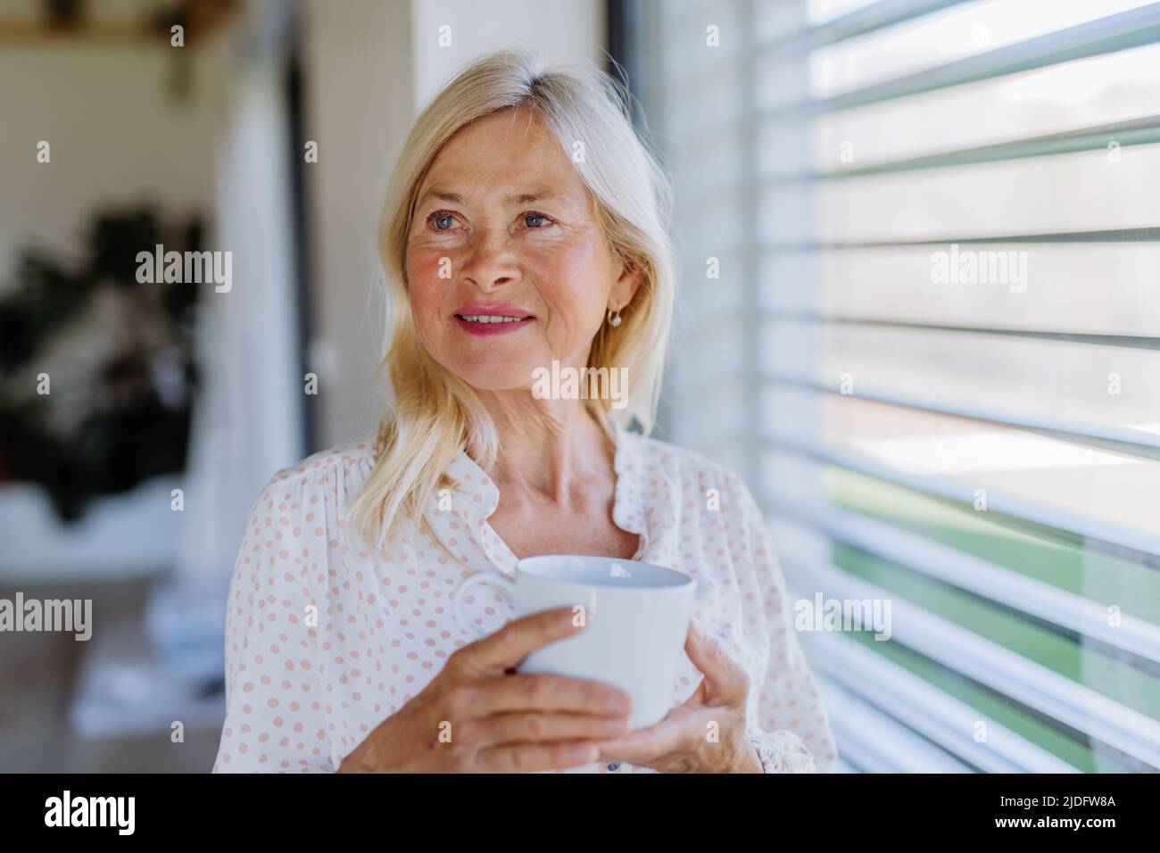 Senior woman cup standing hi-res stock photography and images - Alamy