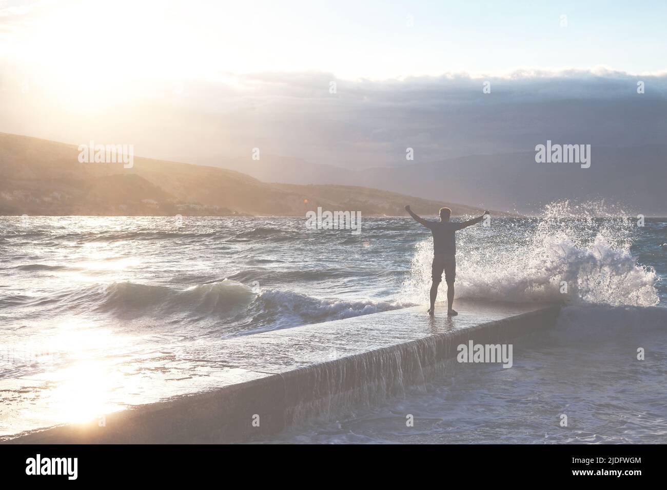 Feeling of freedom concept. Man standing on pier facing to the sea with ...