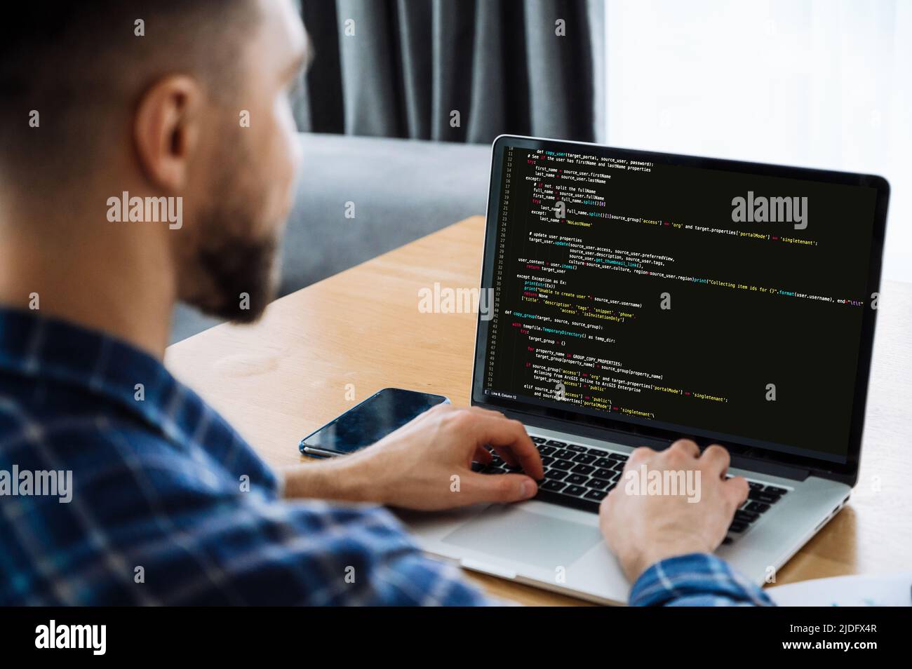 Developing coding technologies, IT concept. Over shoulder view of male IT-specialist to a laptop ...