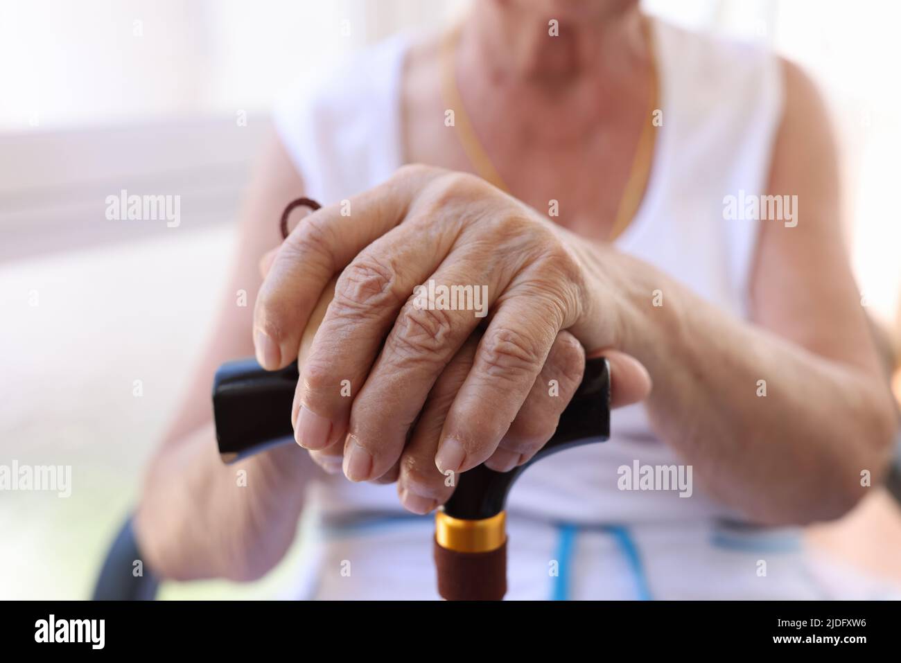 Close-up of hands of old woman holding walking cane. Senior female ...