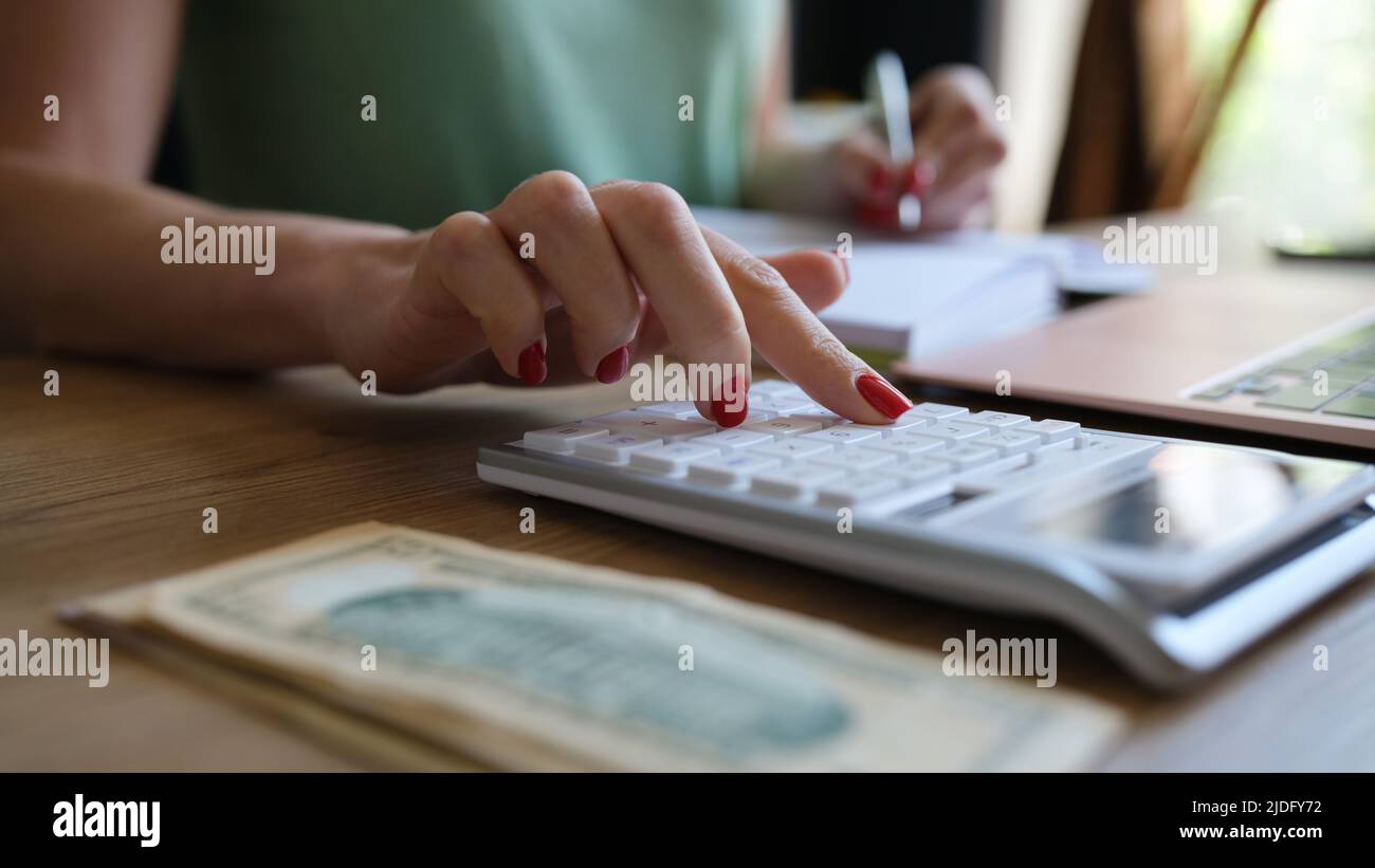 Close-up of woman doing calculation of expenses and income and making ...