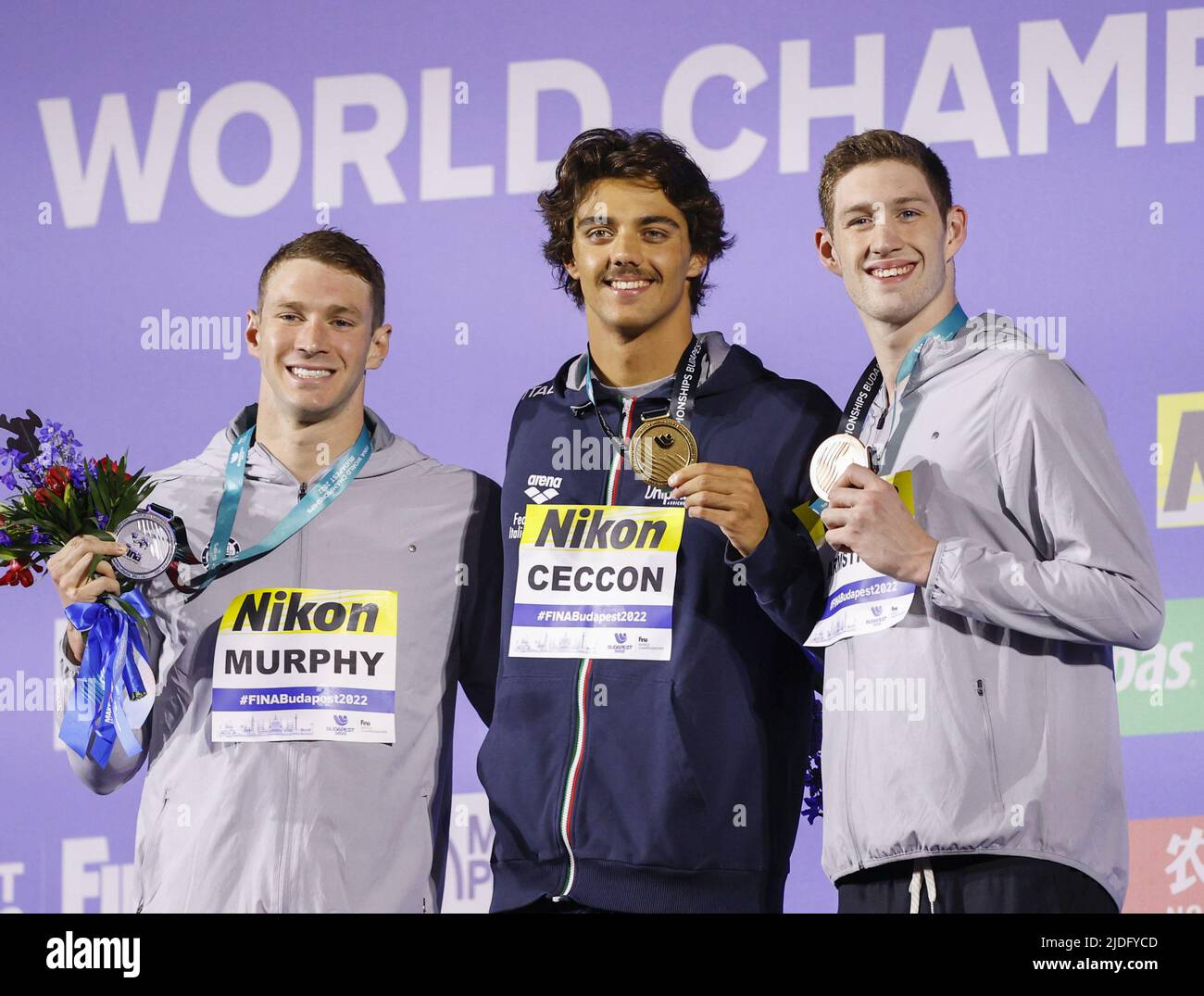 Thomas Ceccon (C) of Italy poses after winning gold in the men's 100 ...