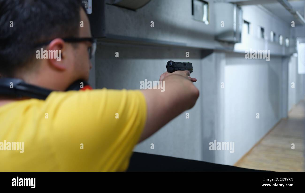 Man aiming pistol at target in shooting range Stock Photo - Alamy