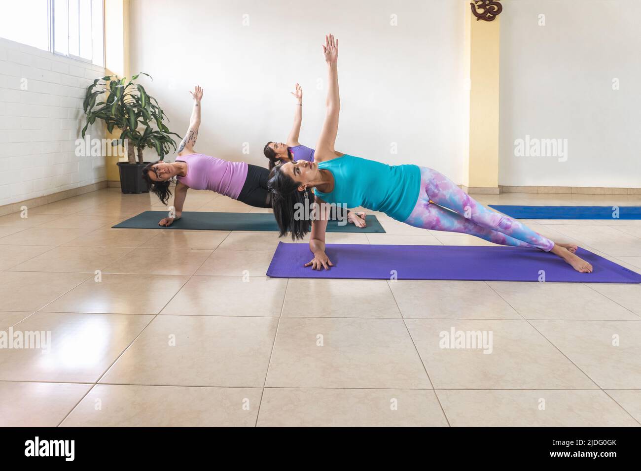three women practicing side plank yoga pose. Vasisthasana pose Stock ...