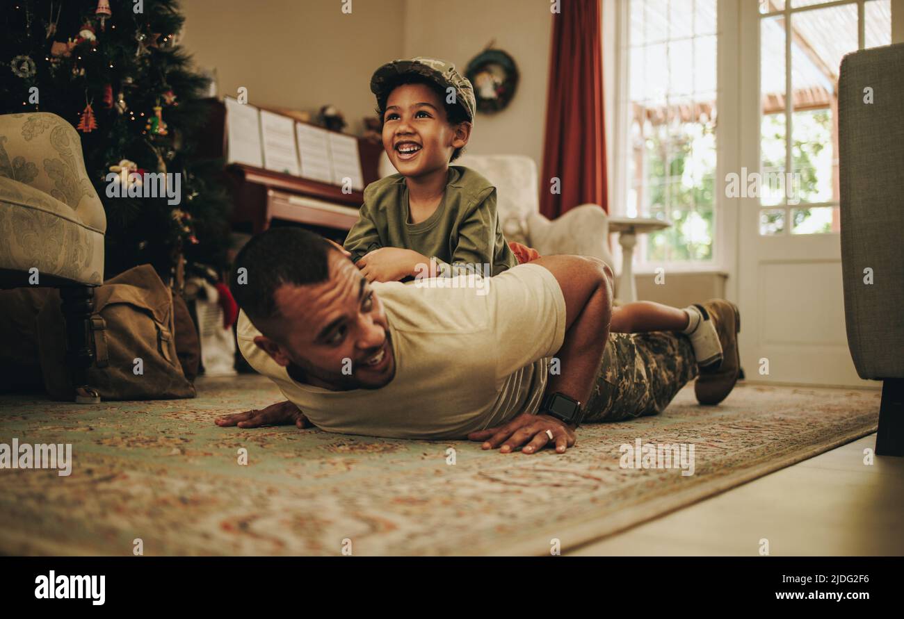 Army soldier spending quality time with his son at Christmas. Happy ...