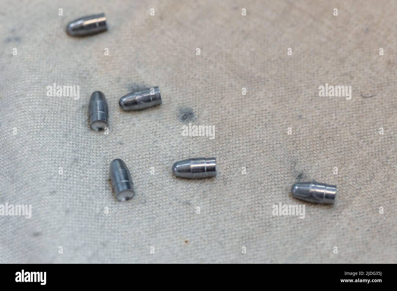 Small caliber bullets on rough fabric at production plant Stock Photo ...
