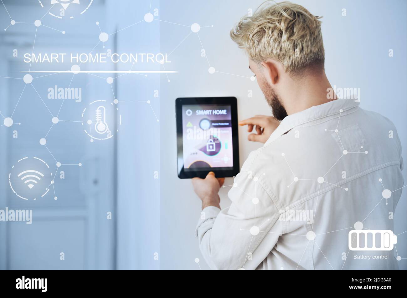 Man with tablet computer using application of smart home automation in ...