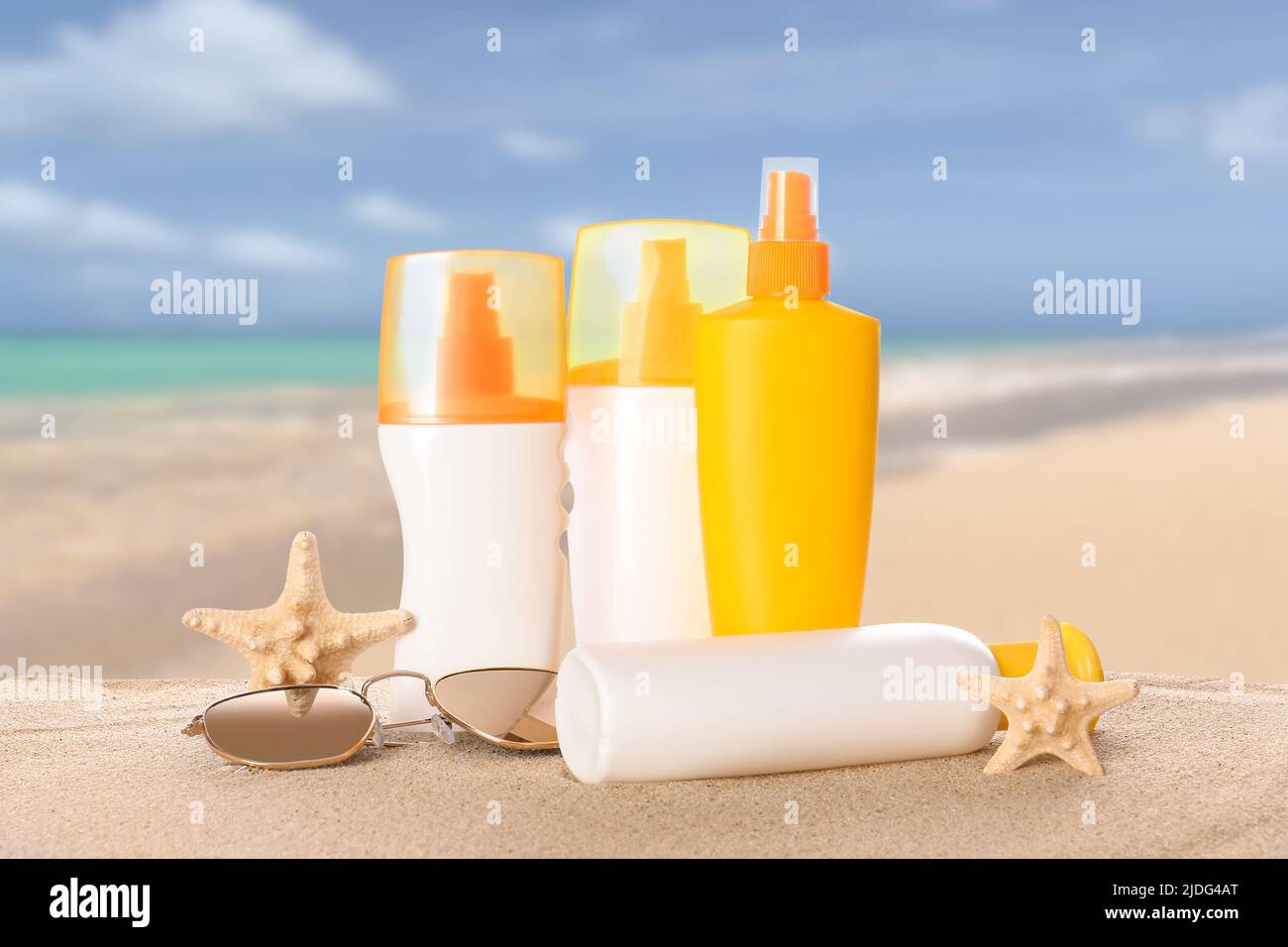 Sunscreen creams, starfish and sunglasses on sand at sea resort Stock ...