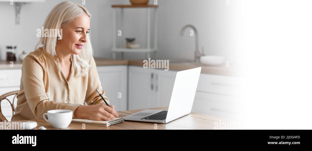 Mature woman with laptop working in kitchen. Banner for design Stock ...