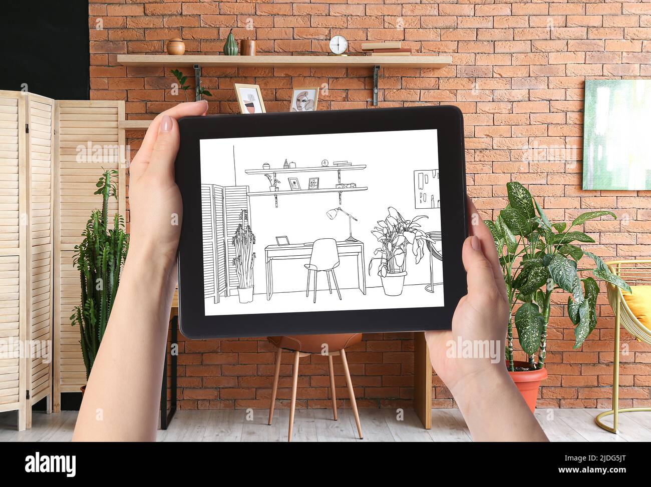 Designer holding tablet computer with drawing of new office interior ...