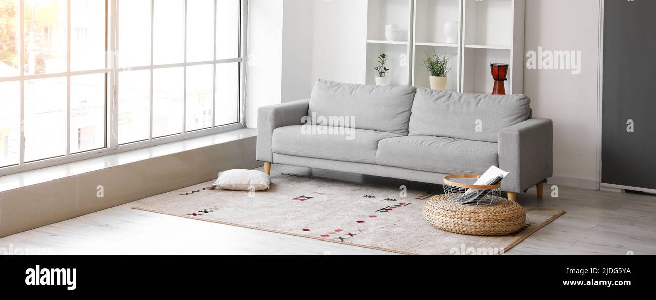 Interior of modern room with shelf unit and sofa near window Stock ...
