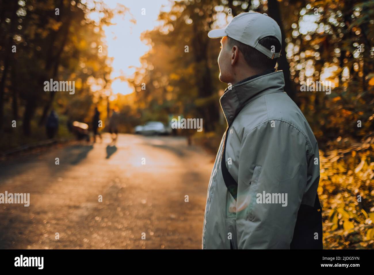 Young man is standing back outside alone on the street in the evening ...