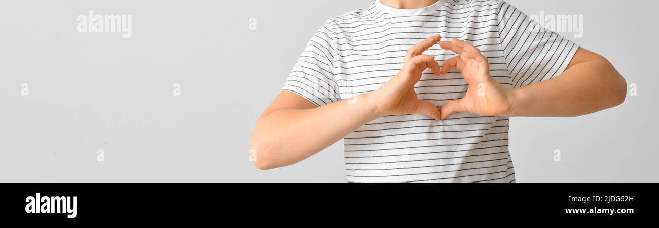 Cute little boy making heart with his hands on grey background. Banner ...