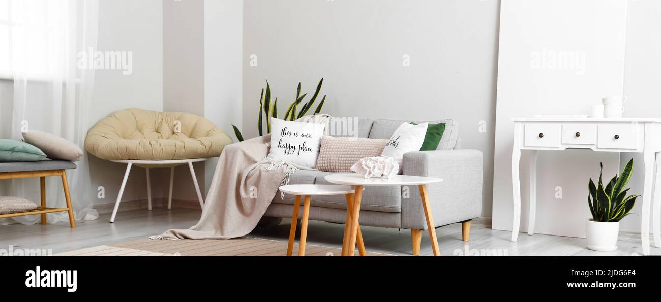 Interior of light living room with sofa and tables Stock Photo - Alamy